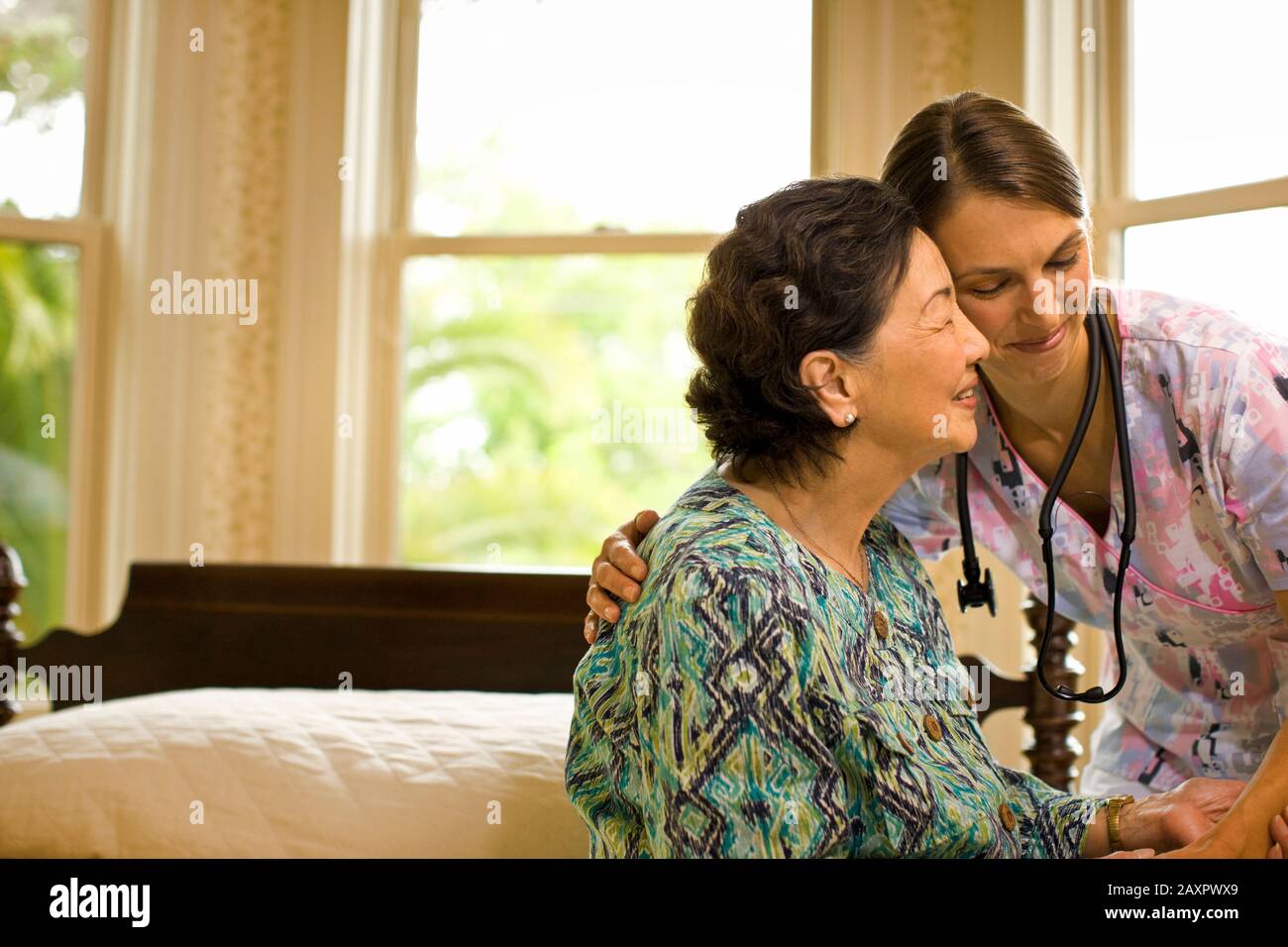 Female nurse gives a senior woman a reassuring hug Stock Photo - Alamy