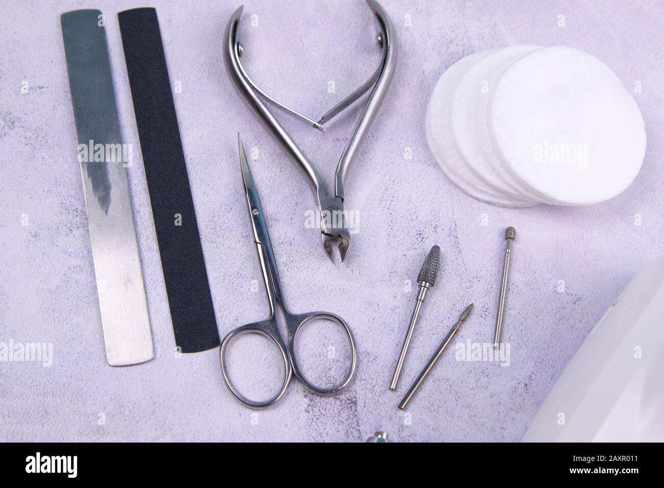 Set of cosmetic tools for manicure and pedicure on a concrete ...