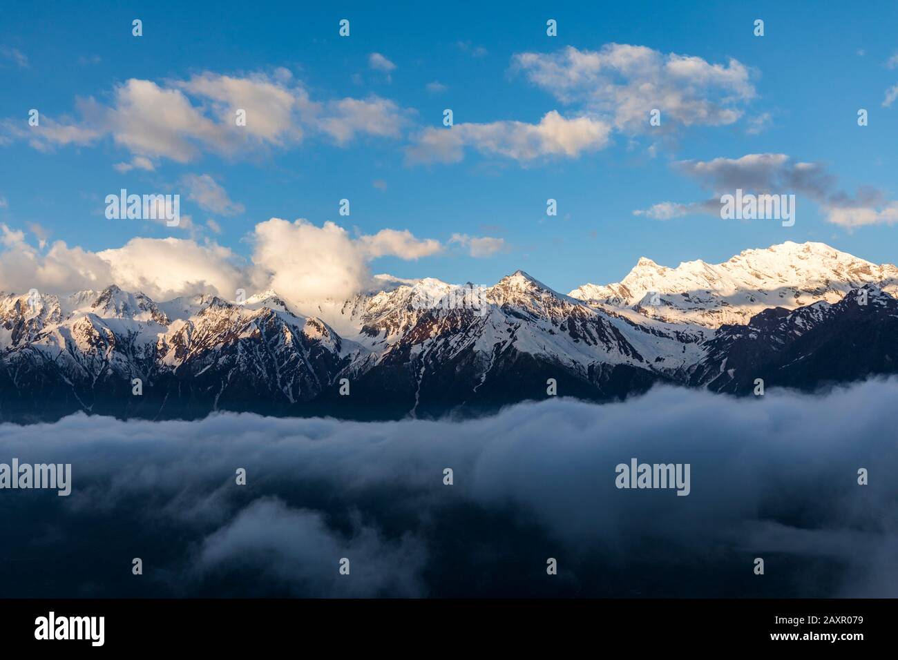 Alpine landscape with snowy mountain ridge and low cloud, Himalaya ...