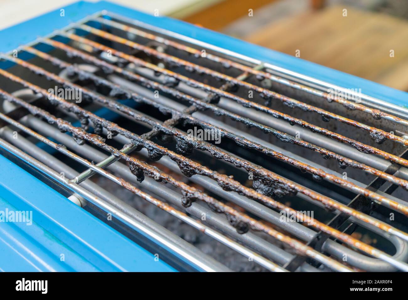 Dirty black mark burned on grilled above blue electric stove from oil ...