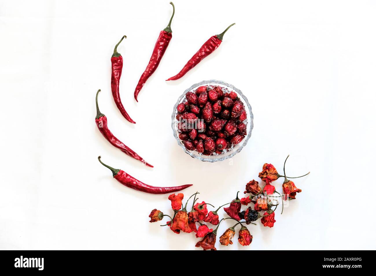 Dried red chili peppers and rose hips (berry) on white background Stock ...