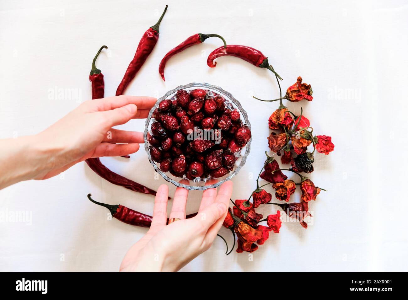 Dried red chili peppers and rose hips (berry) on white background Stock ...