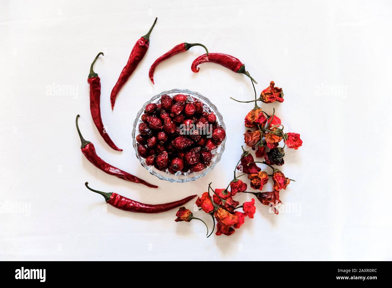 Dried red chili peppers and rose hips (berry) on white background Stock ...