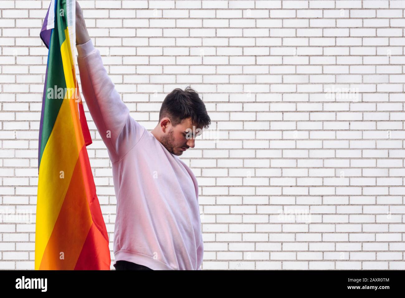 Young man holding gay rainbow flag hi-res stock photography and images ...