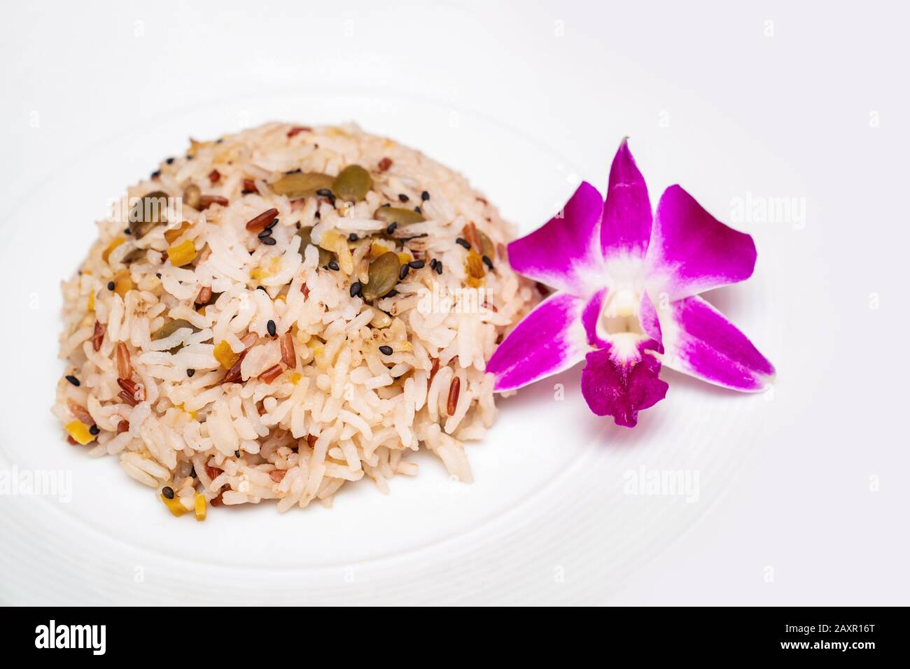 isolated brown rice with the purple orchid beside for decoration on ...