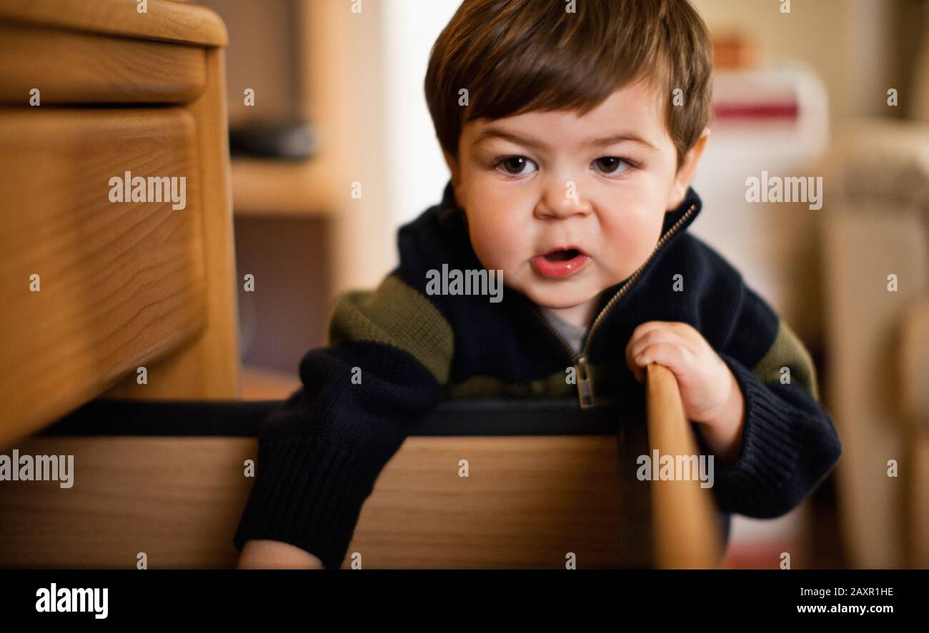 Toddler boy reaching into drawer Stock Photo - Alamy