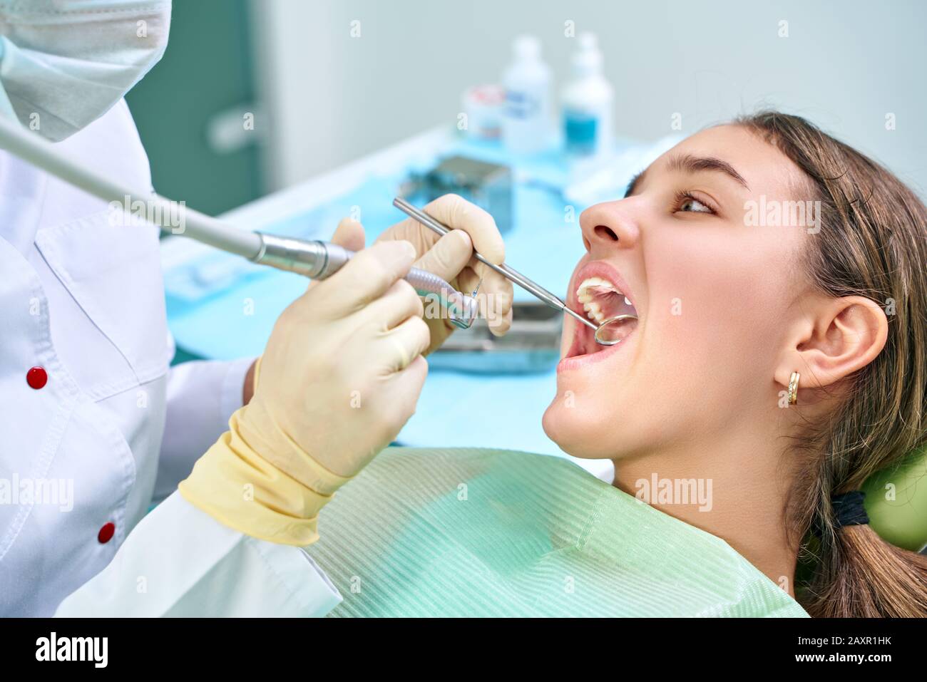 Girl Sitting At Dental Chair With Open Mouth During Oral Check Up While Doctor Visiting Dentist