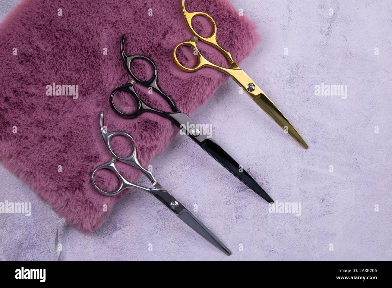 A set of scissors for a haircut and a black dew on a beautiful pink ...