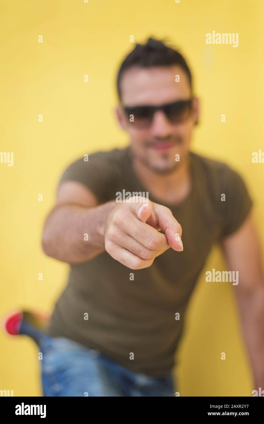 Portrait of a handsome young man pointing finger at you against white ...