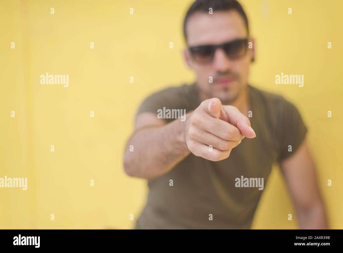 Portrait of a handsome young man pointing finger at you against white ...