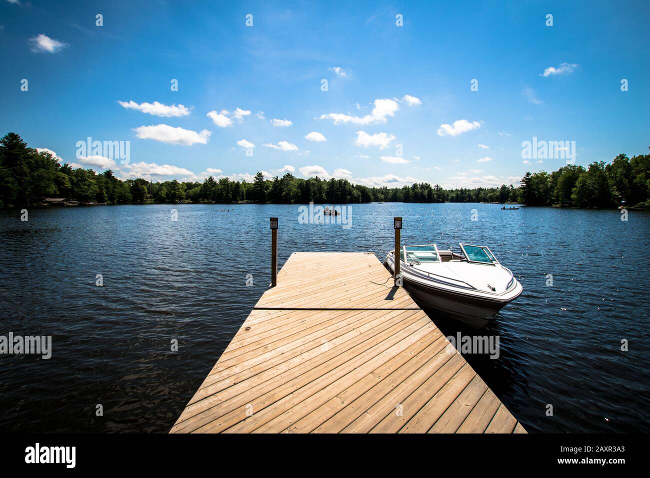 Lake dock with boat Stock Photo - Alamy