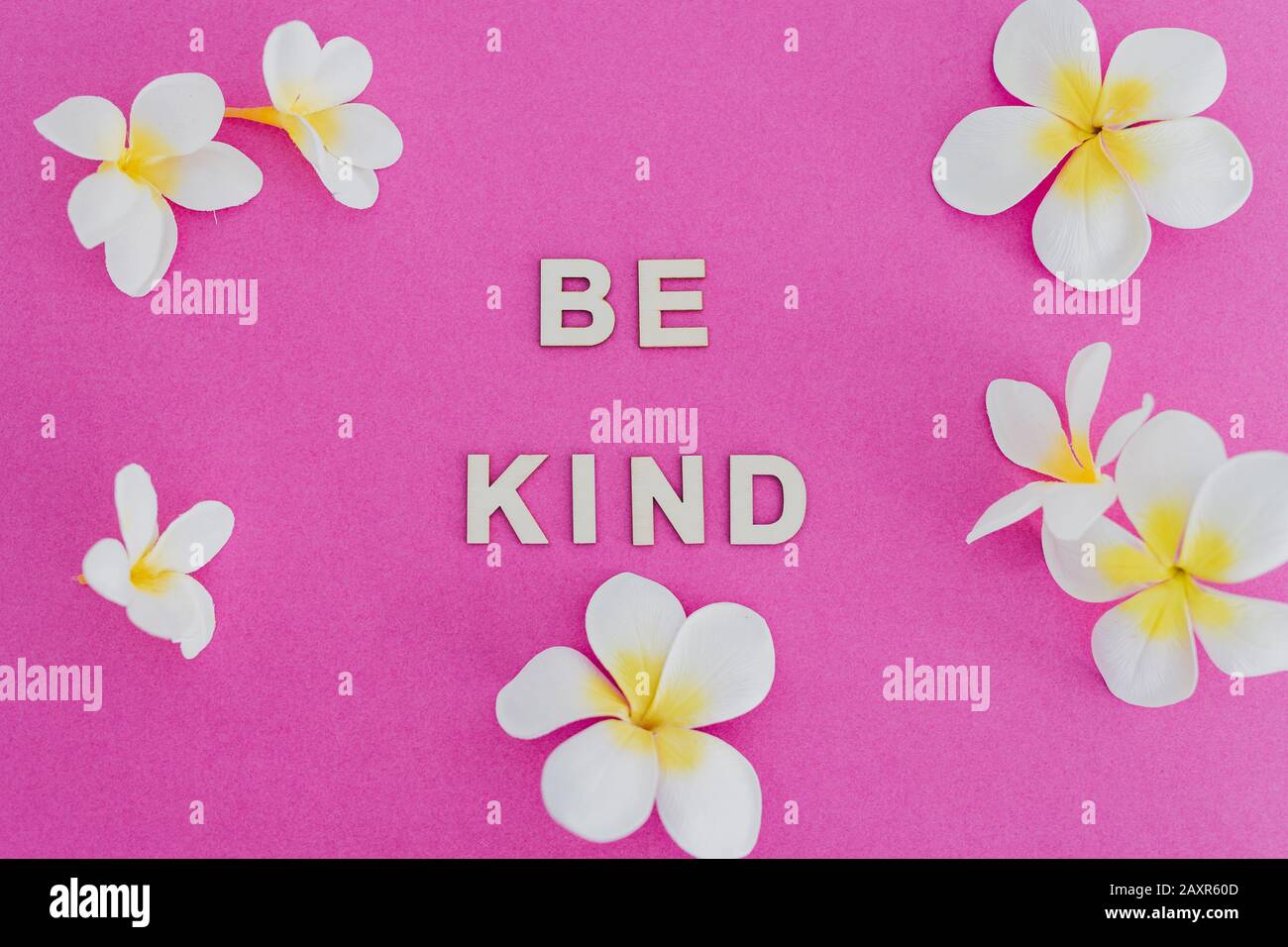 Be Kind message on pink background surrounded by flowers, concept of ...