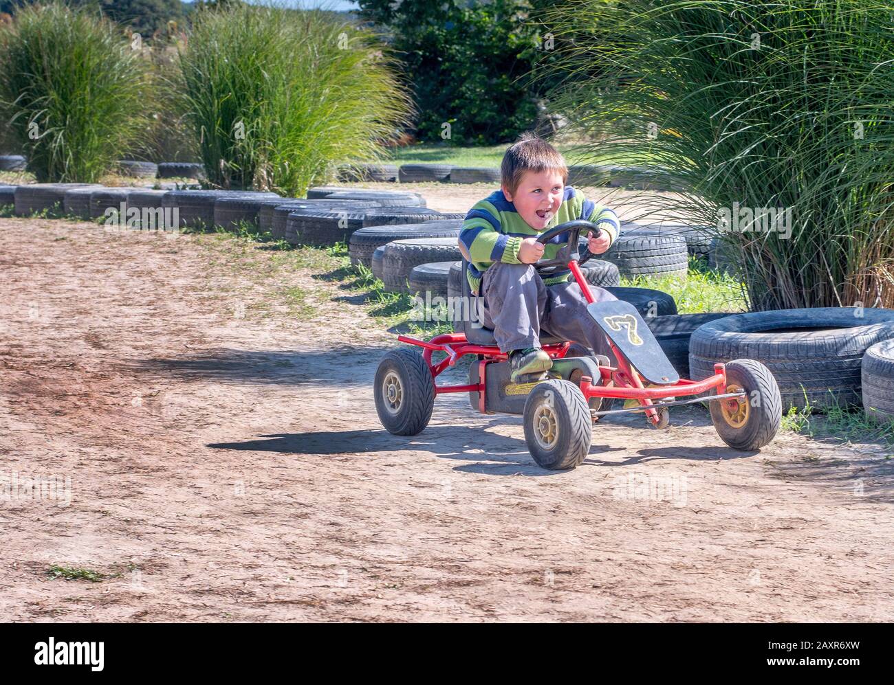 A happy little boy is a little speed racer in a pedal car Stock Photo ...