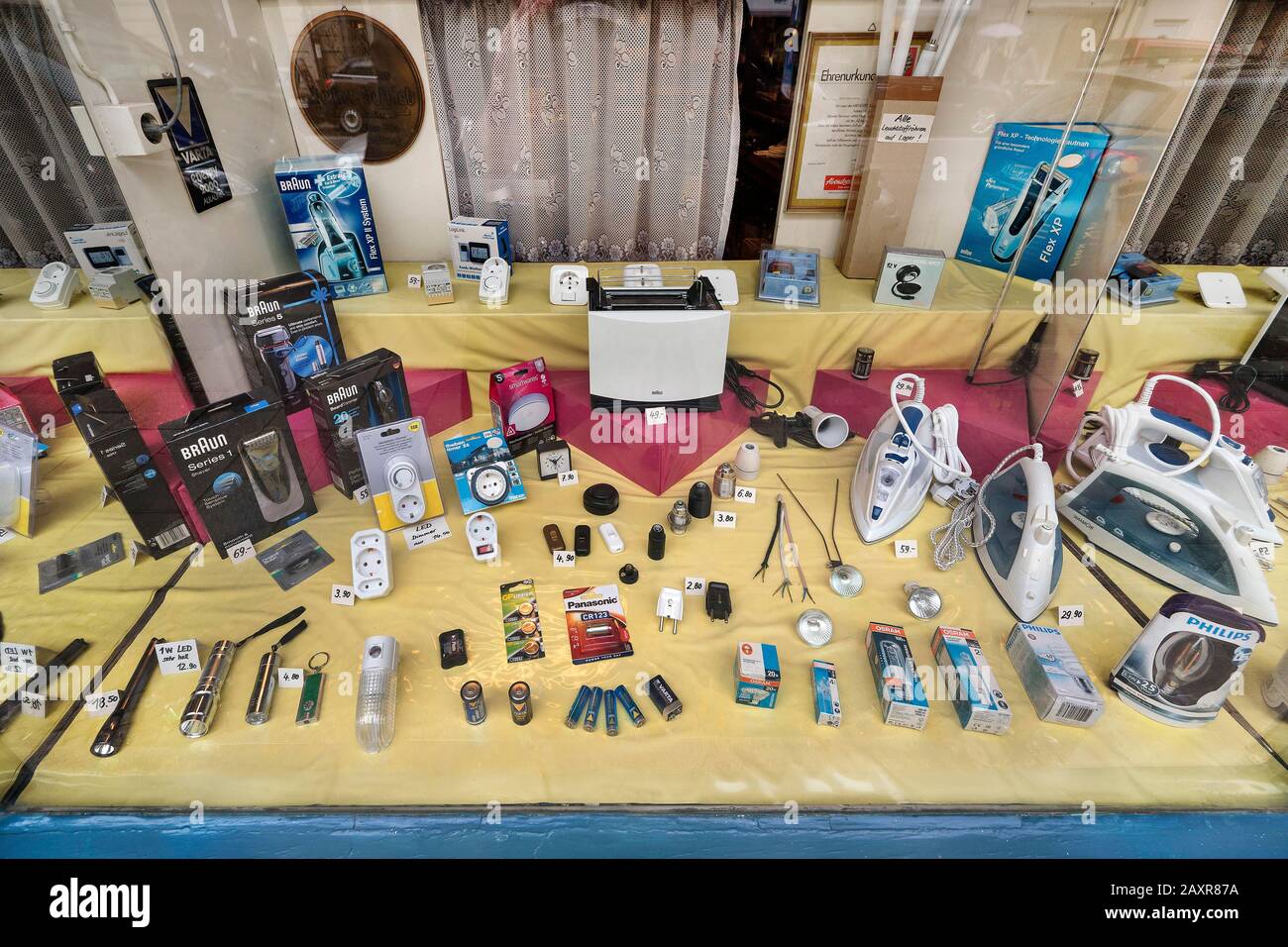 Shop window of an electrical corner shop with curtains in the ...