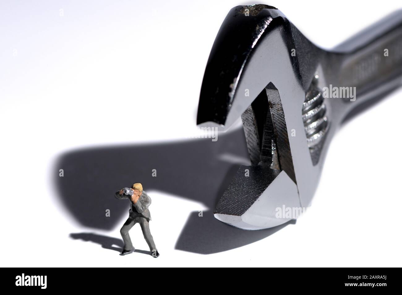 Adjustable wrench with figurine shadow on white background. Abstract ...