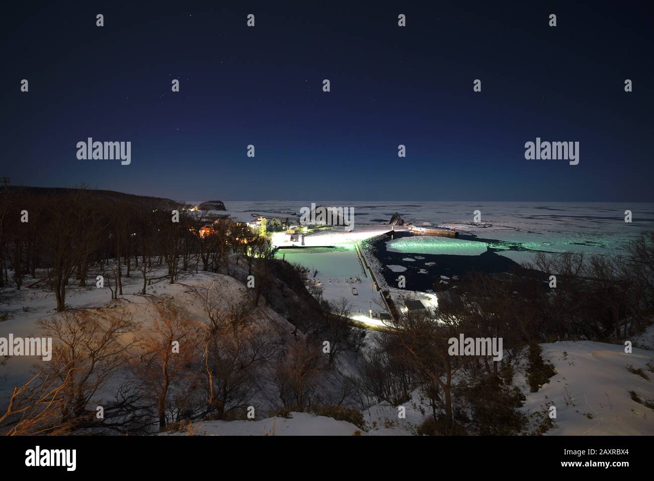 Night view of Utoro port area in winter with Okhotsk sea covered in ...