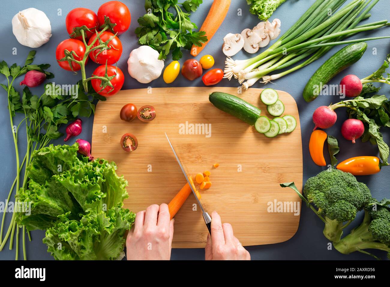 Top view of woman cooking healthy food: cutting vegetable ingredients ...