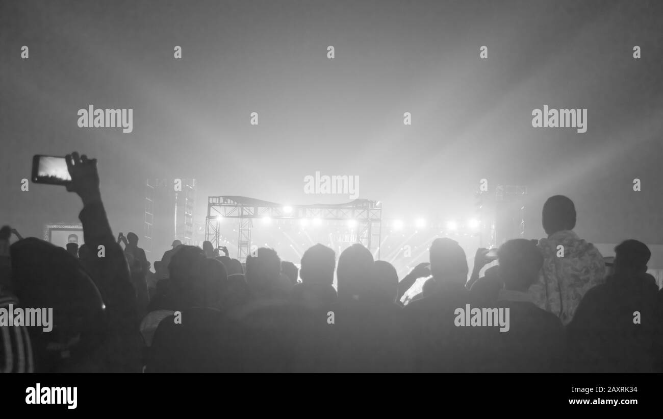 Silhouette of big audience crowd of happy people standing at concert ...