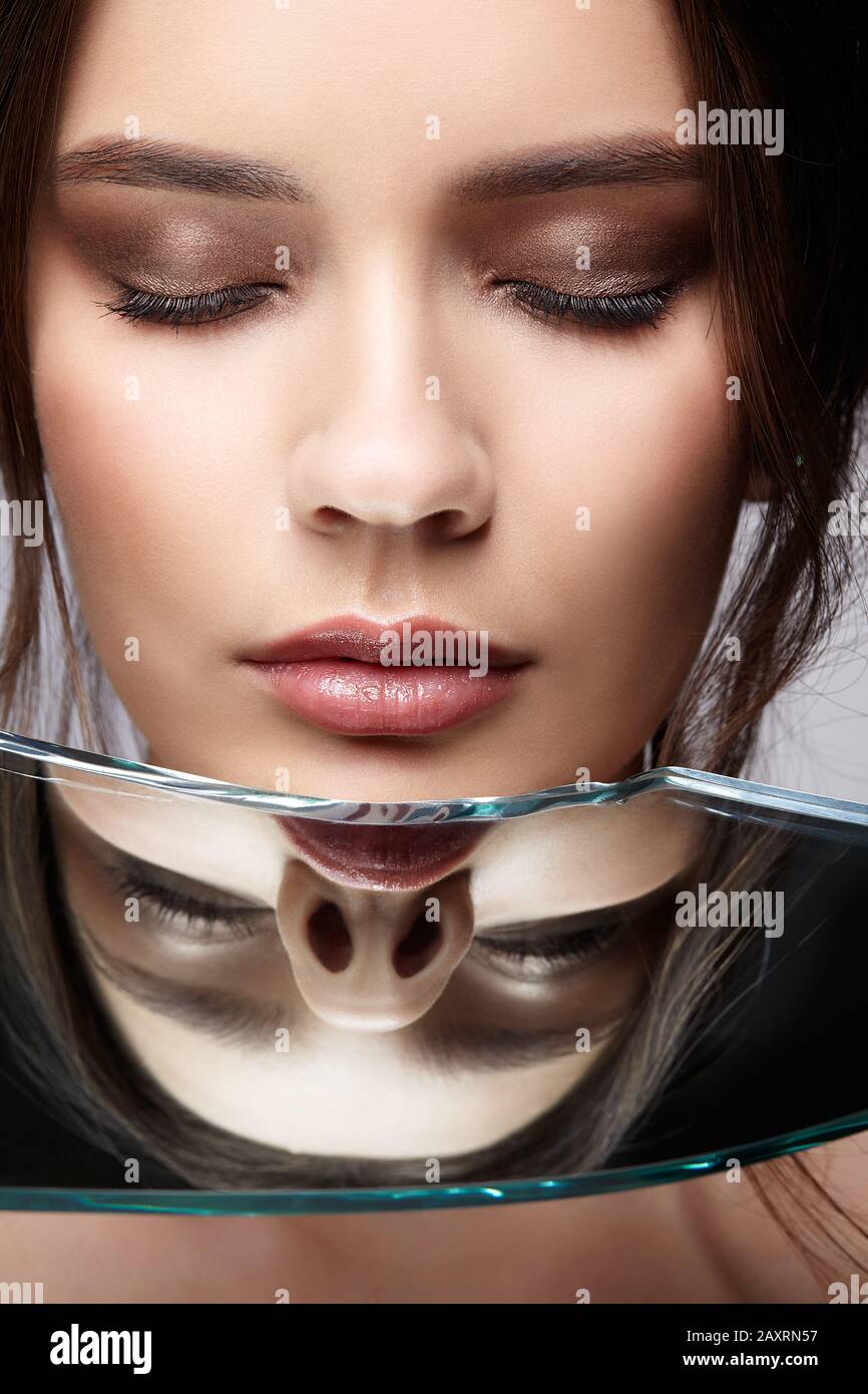 Portrait of a beautiful girl with reflection in a mirror splinter ...