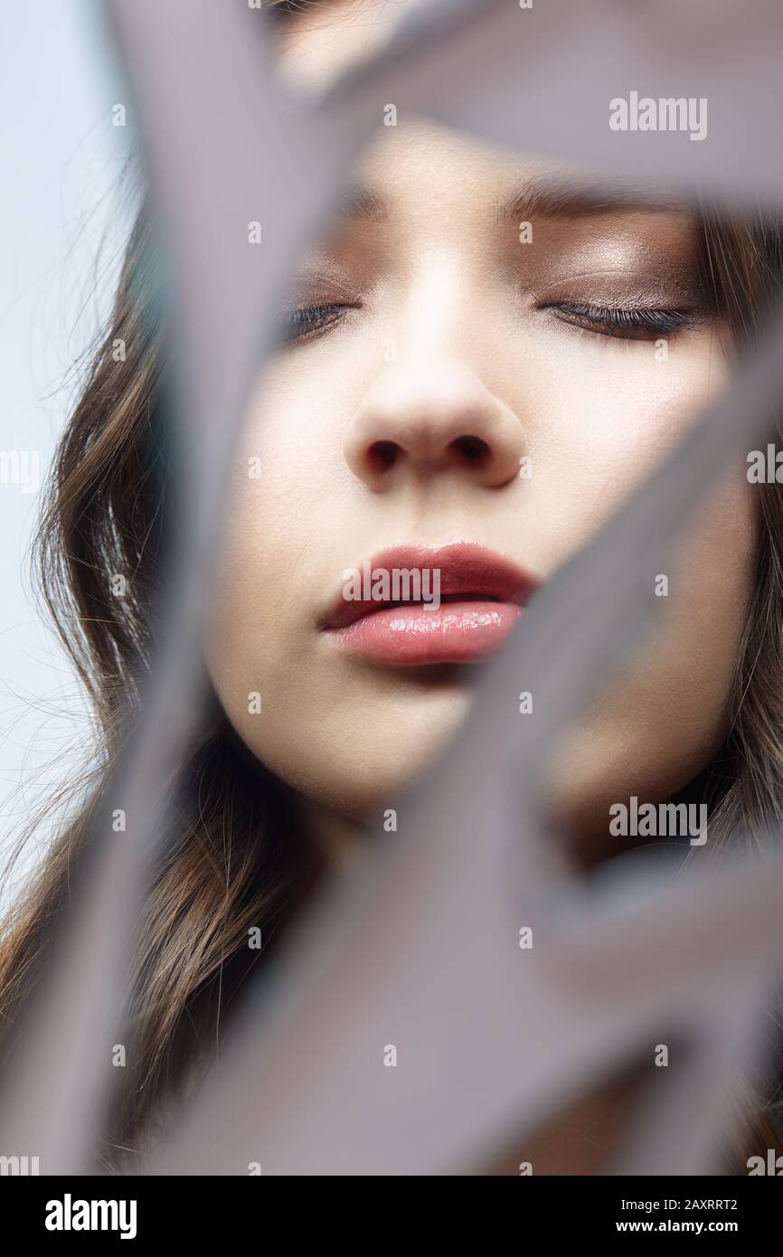 Young woman looks in a broken mirror. Portrait of beautiful female in ...