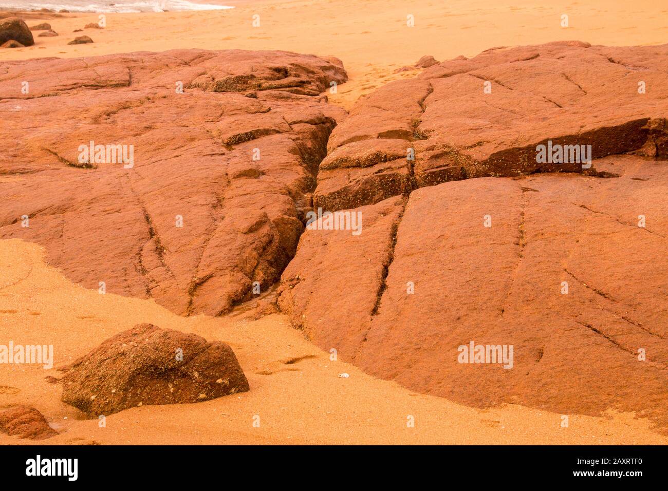 Beach sand and large rocks line the seashore Stock Photo - Alamy