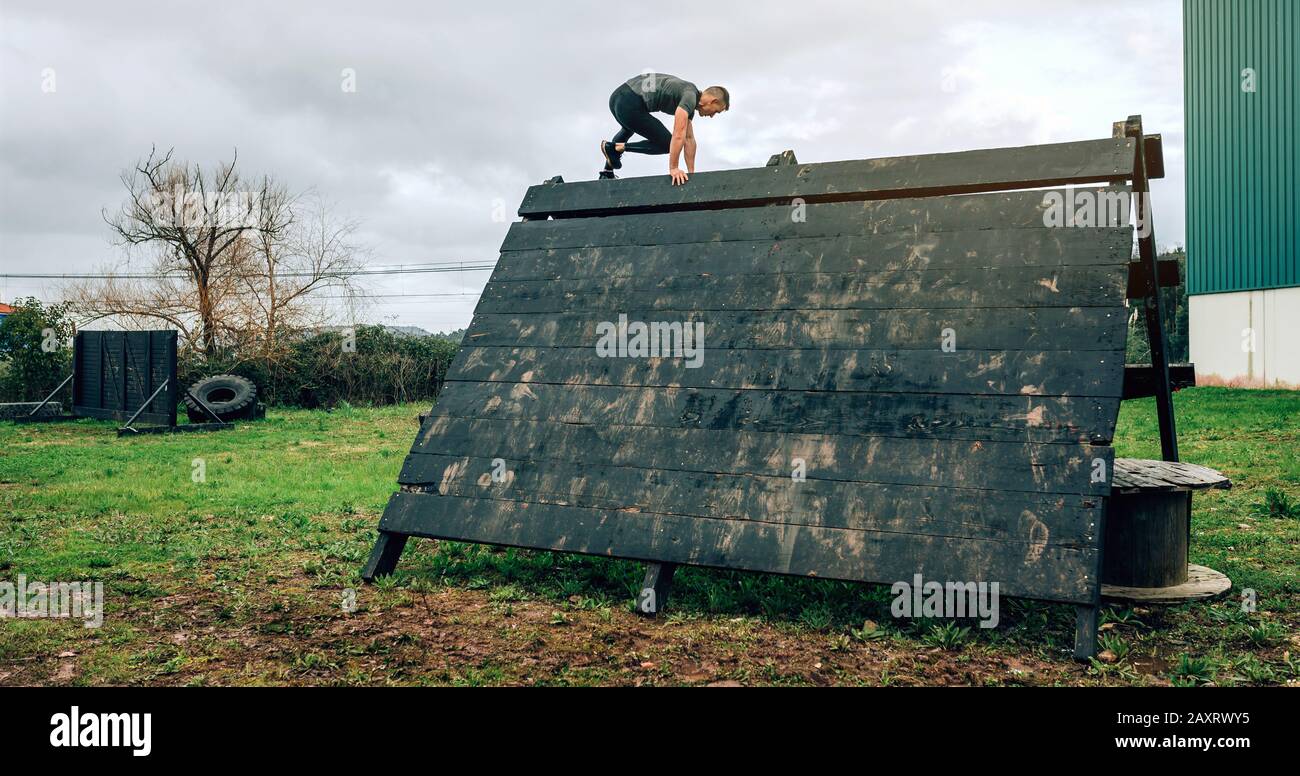 Participant in obstacle course climbing pyramid obstacle Stock Photo ...