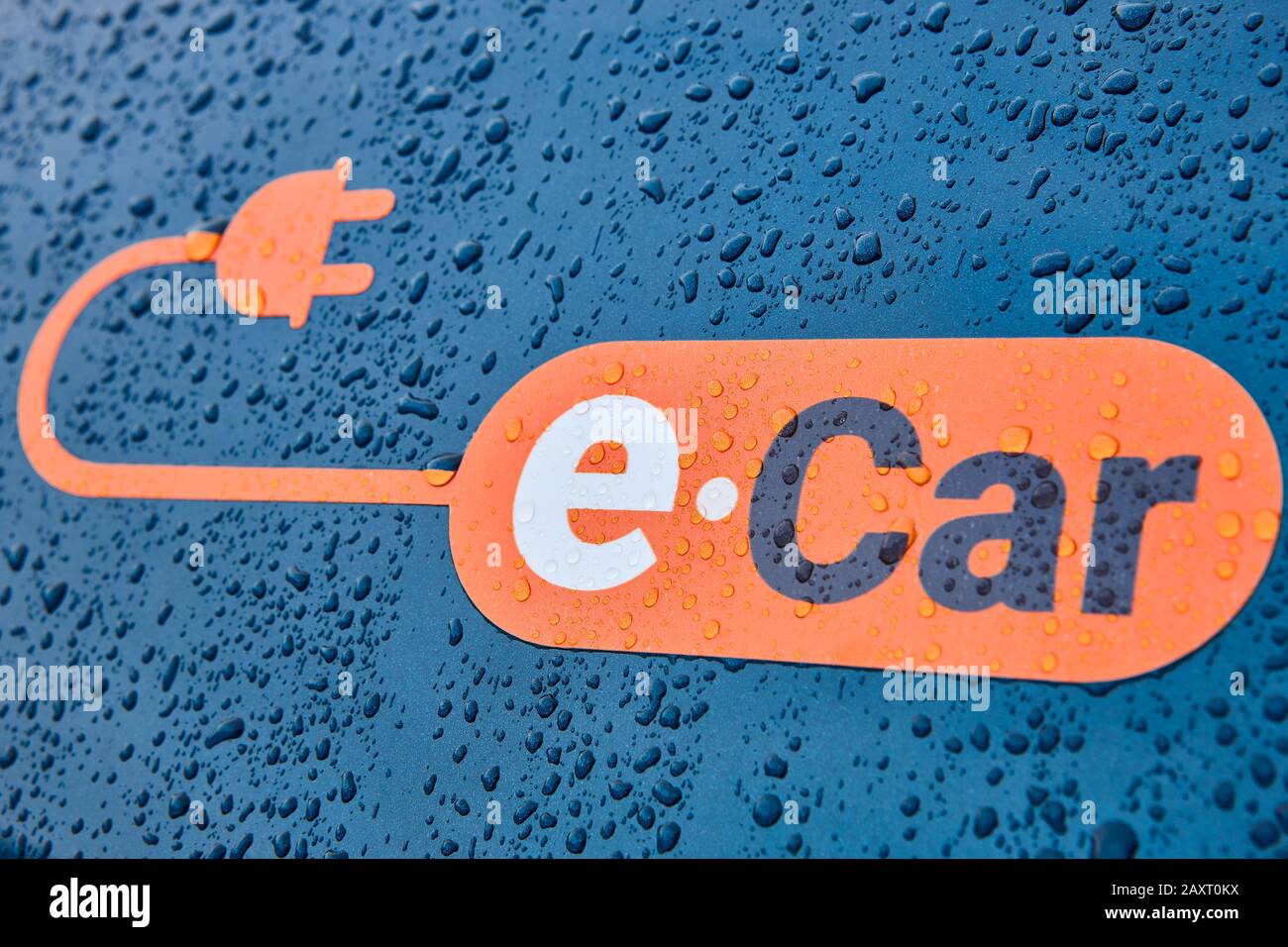 Electric car logo on a car body with rain drops Stock Photo - Alamy
