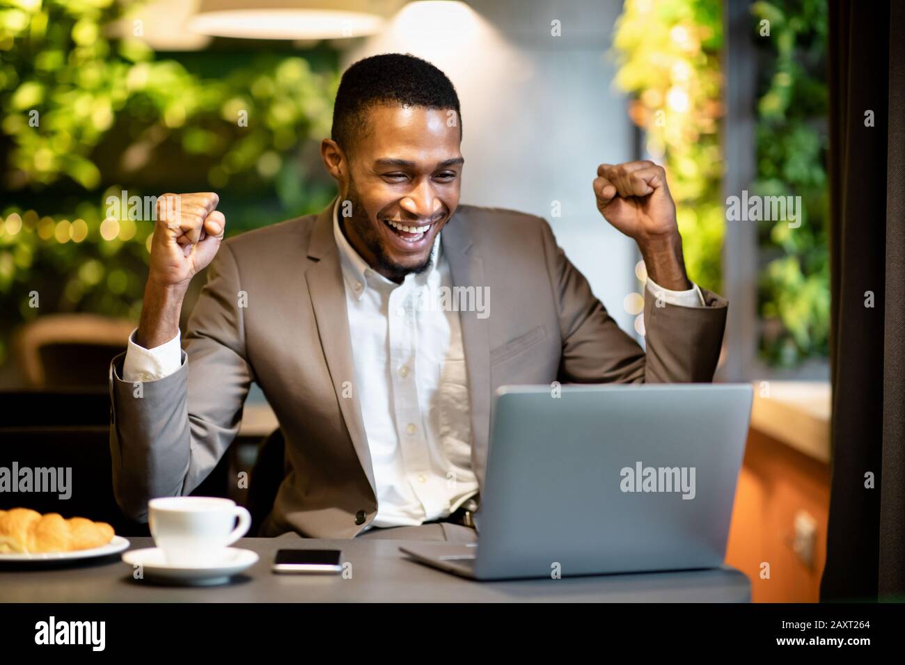 Excited black manager celebrating his victory at the cafe Stock Photo ...