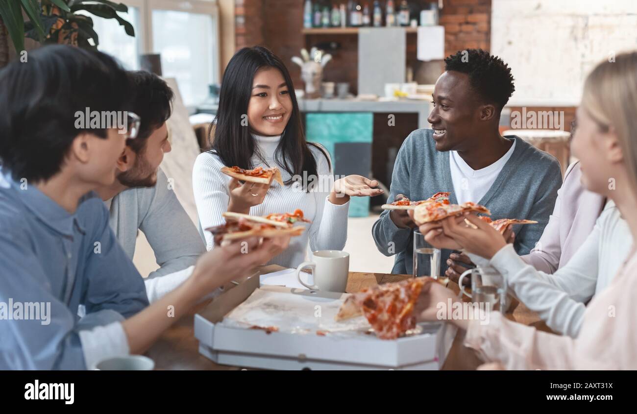 Cheerful colleagues eating take away food in office Stock Photo - Alamy