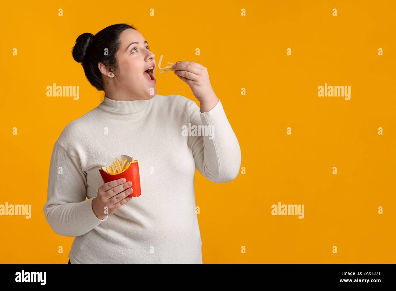 Overweight woman eating chips hi-res stock photography and images - Alamy