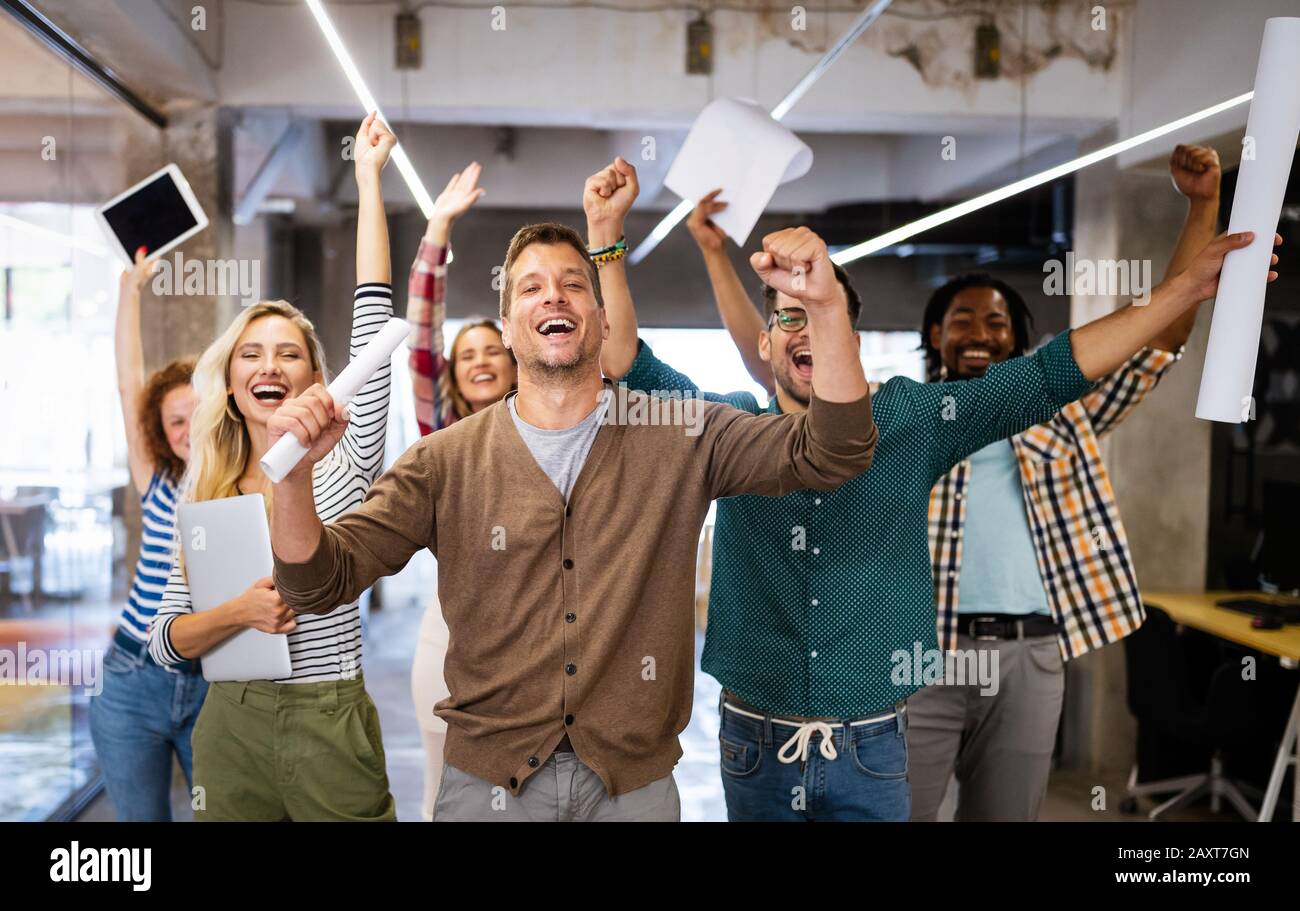 Happy business people celebrating success at company Stock Photo - Alamy
