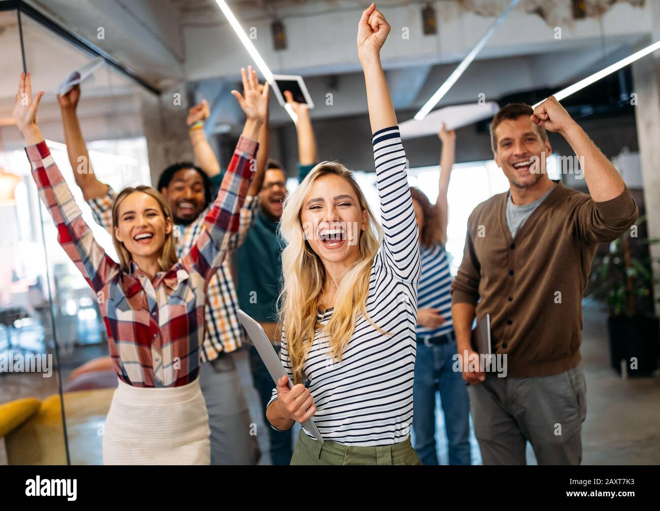 Happy business people celebrating success at company Stock Photo - Alamy