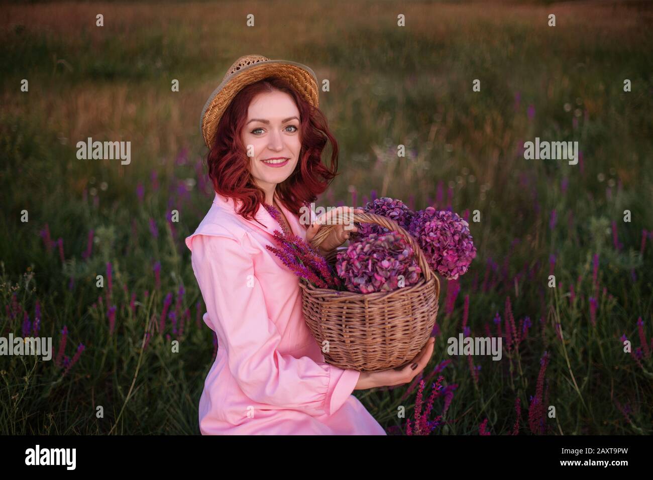 Beautiful young smiling woman in pink vintage dress and straw hat in ...
