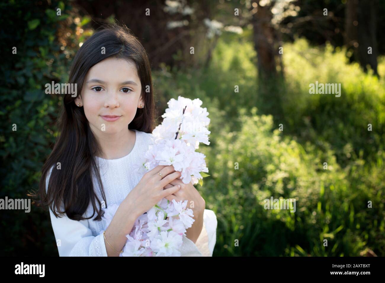 Beautiful girl with white communion dress in nature Stock Photo - Alamy