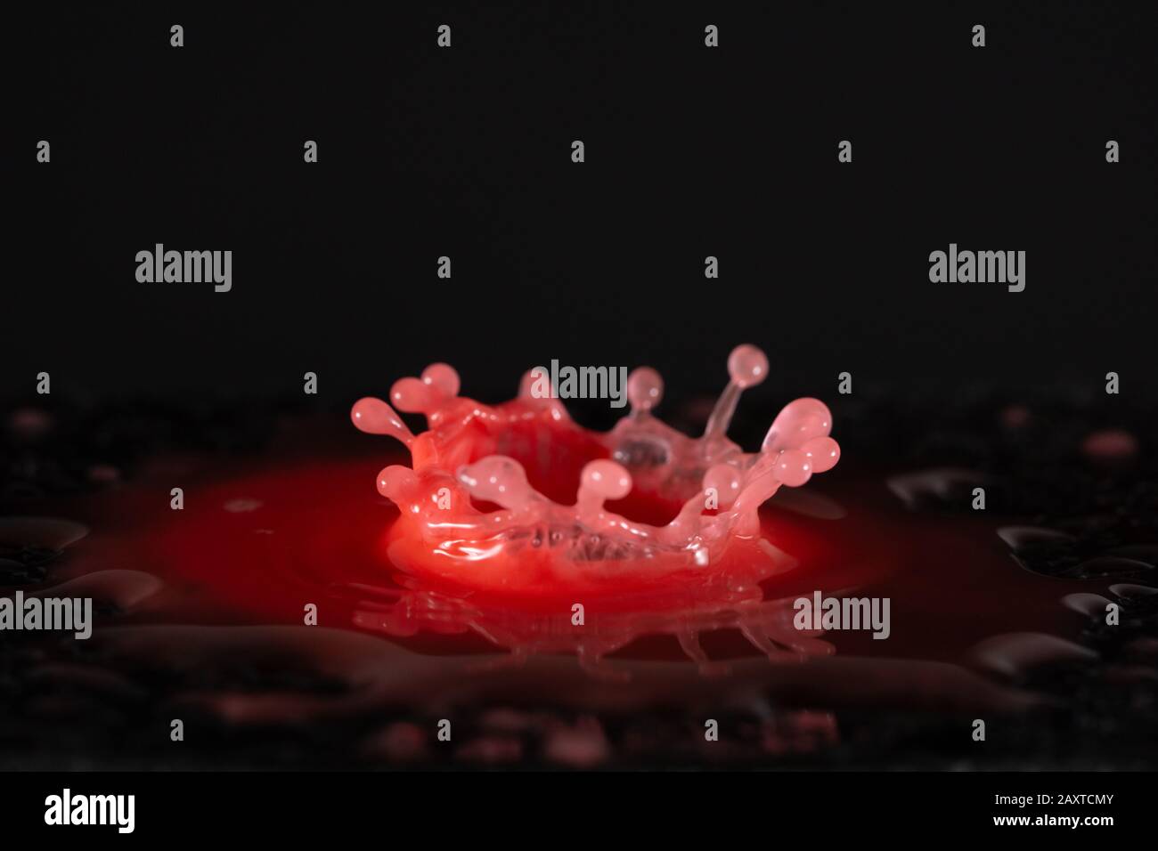 Red liquid ink splash on black background Stock Photo - Alamy