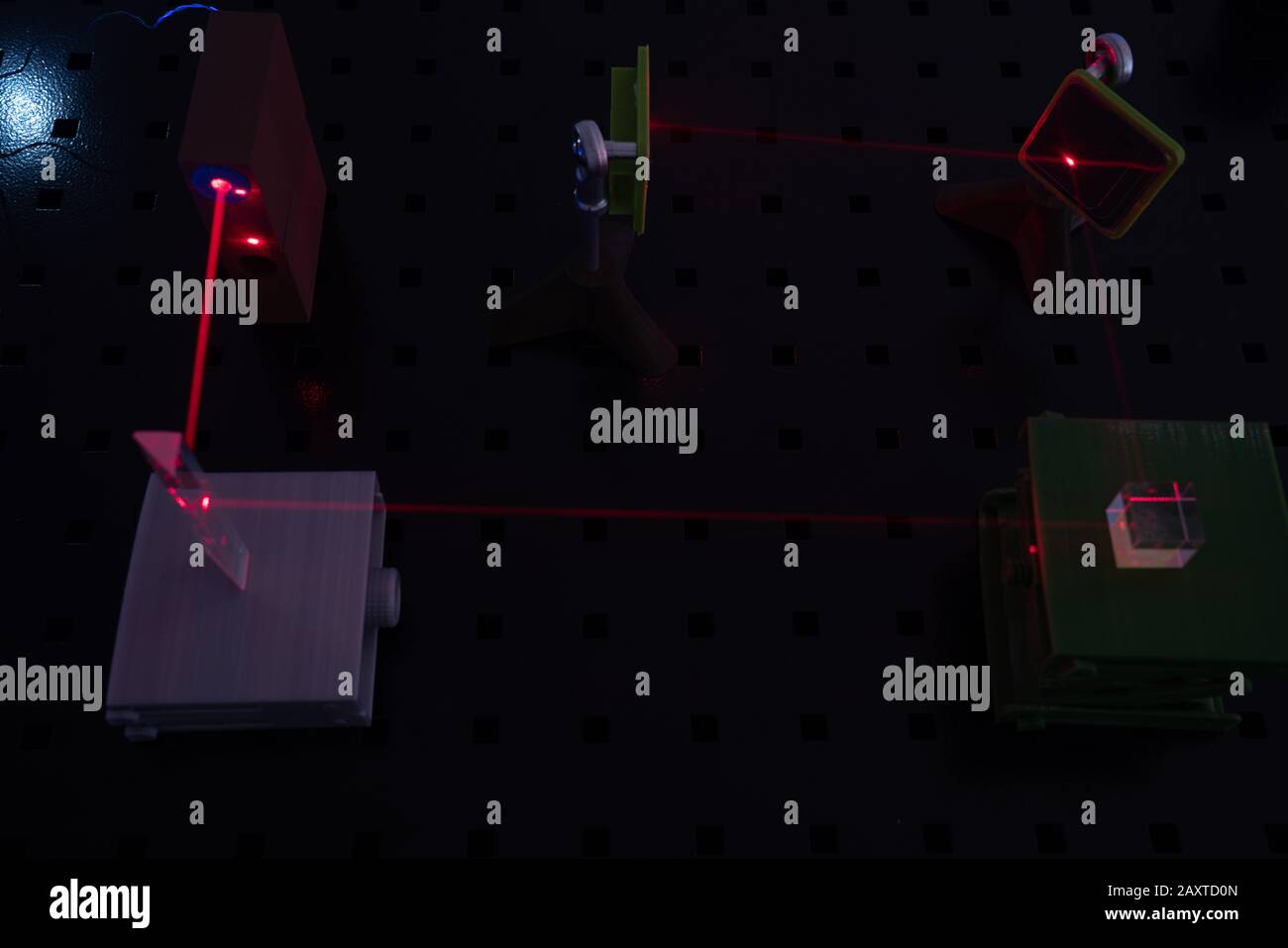 Experiment in optic lab with laser device. Red laser on optical table ...