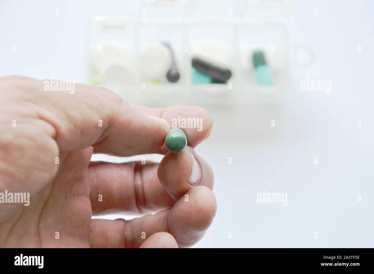 medicine capsule picking in human finger with drug box background Stock ...