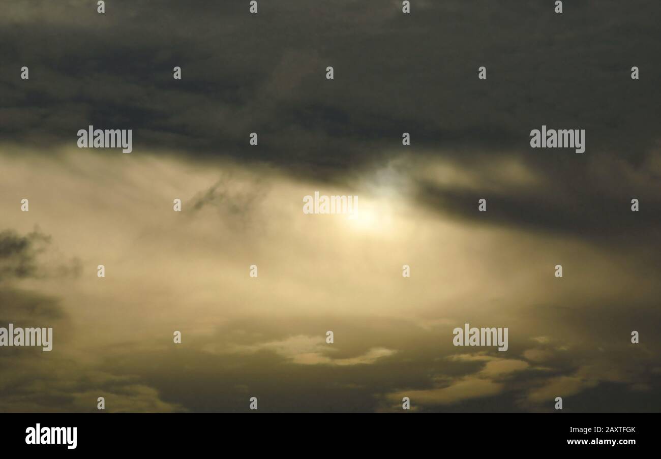 sun behind dark cloud look a like eye on sky Stock Photo - Alamy