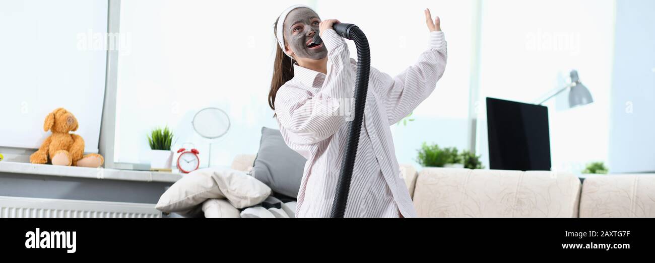 Woman sing song in vacuum cleaner against modern Stock Photo - Alamy
