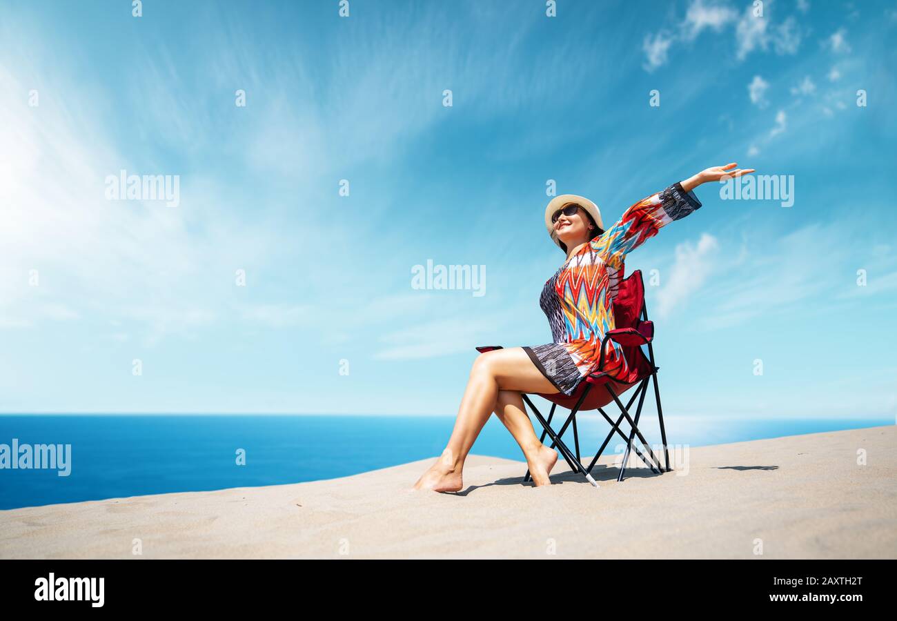 Back view of beautiful sitting woman enjoying the idyllic scene of the ...