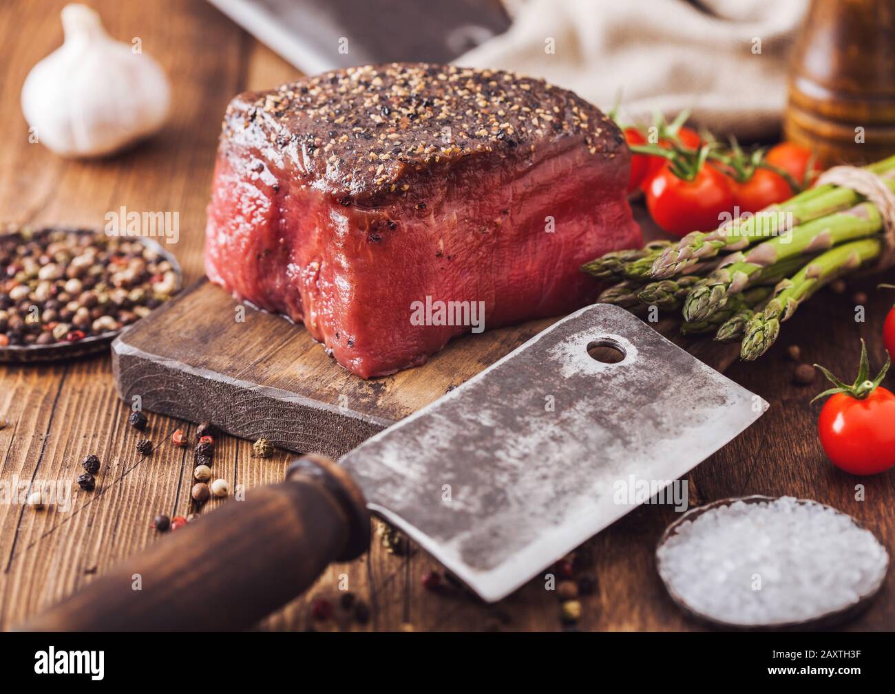Slice of Raw Beef Topside Joint with Salt and Pepper on wooden chopping ...