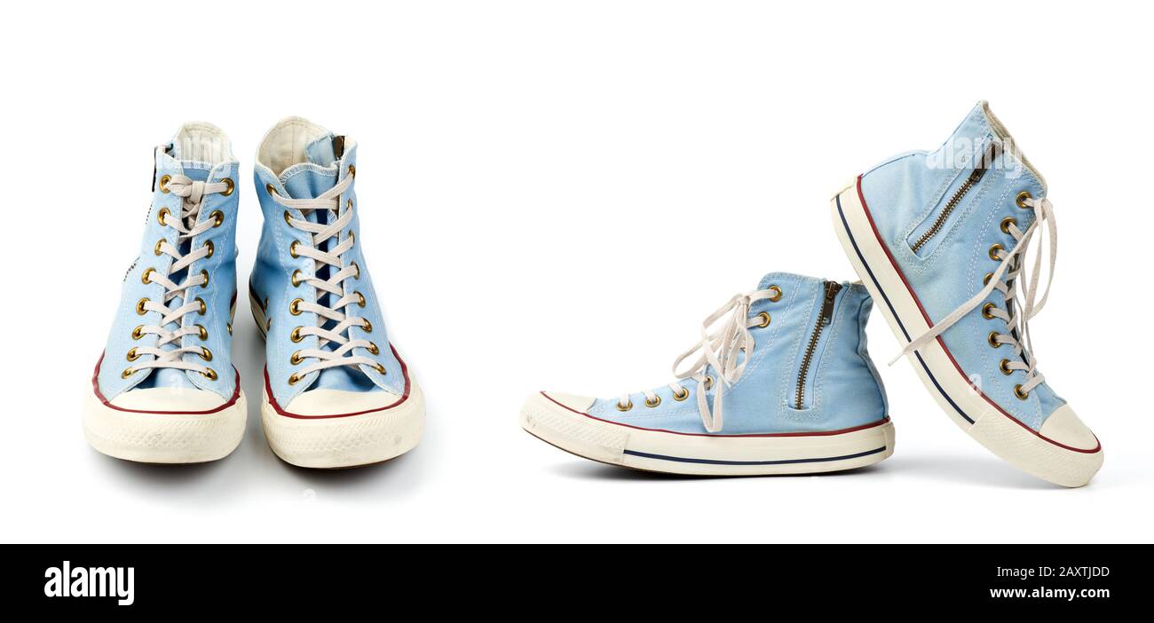 pair of light blue worn textile sneakers with laces and zippers on a ...