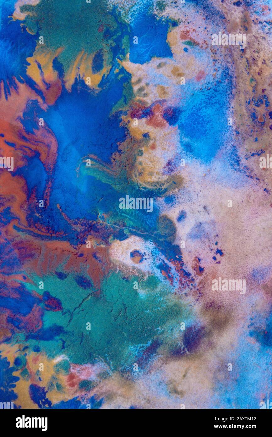 Drops with streaks of different colors of paint are mixed and absorbed ...