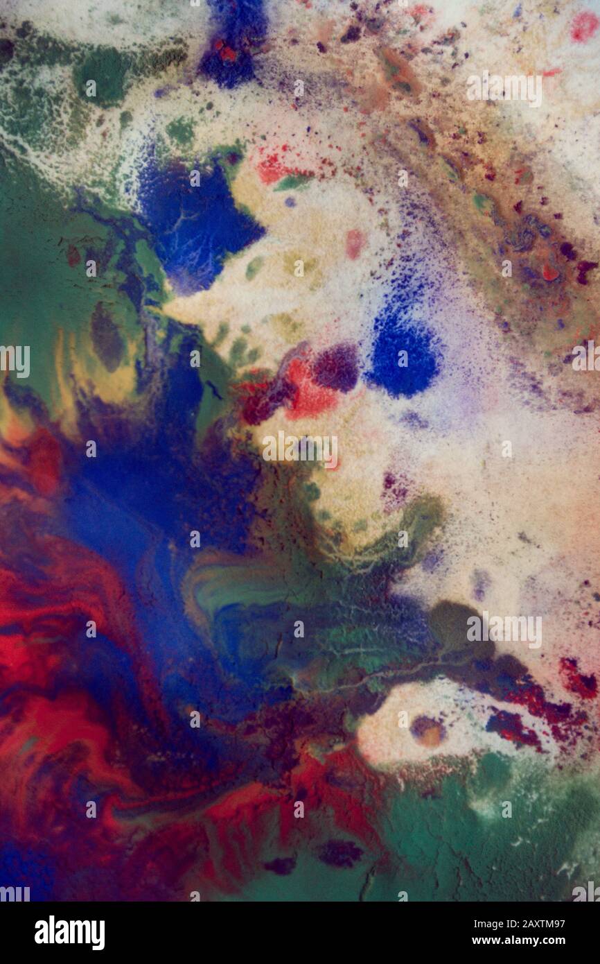 Drops with streaks of different colors of paint are mixed and absorbed ...