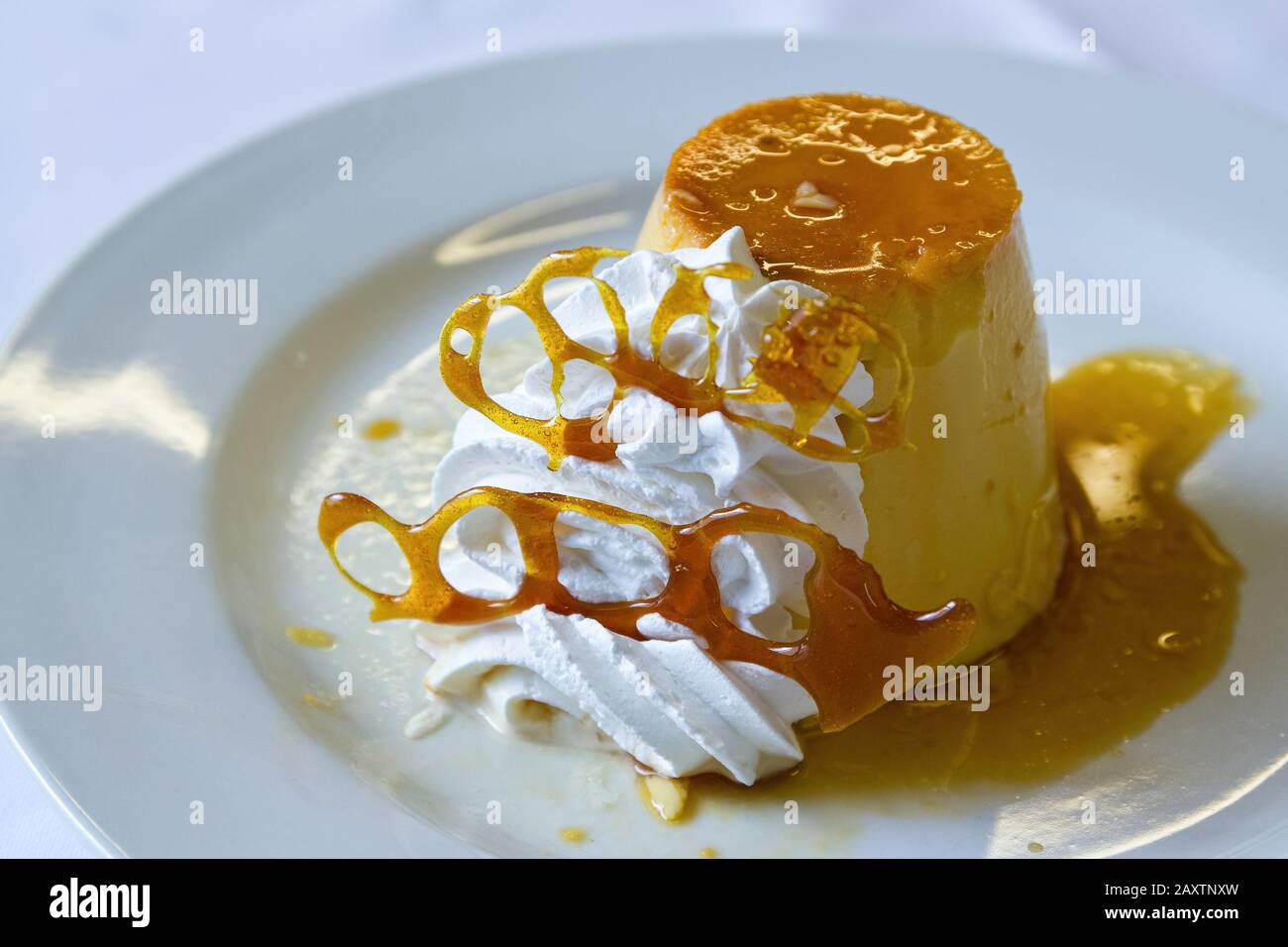 Closeup shot of a delicious crème caramel dessert with white cream on ...