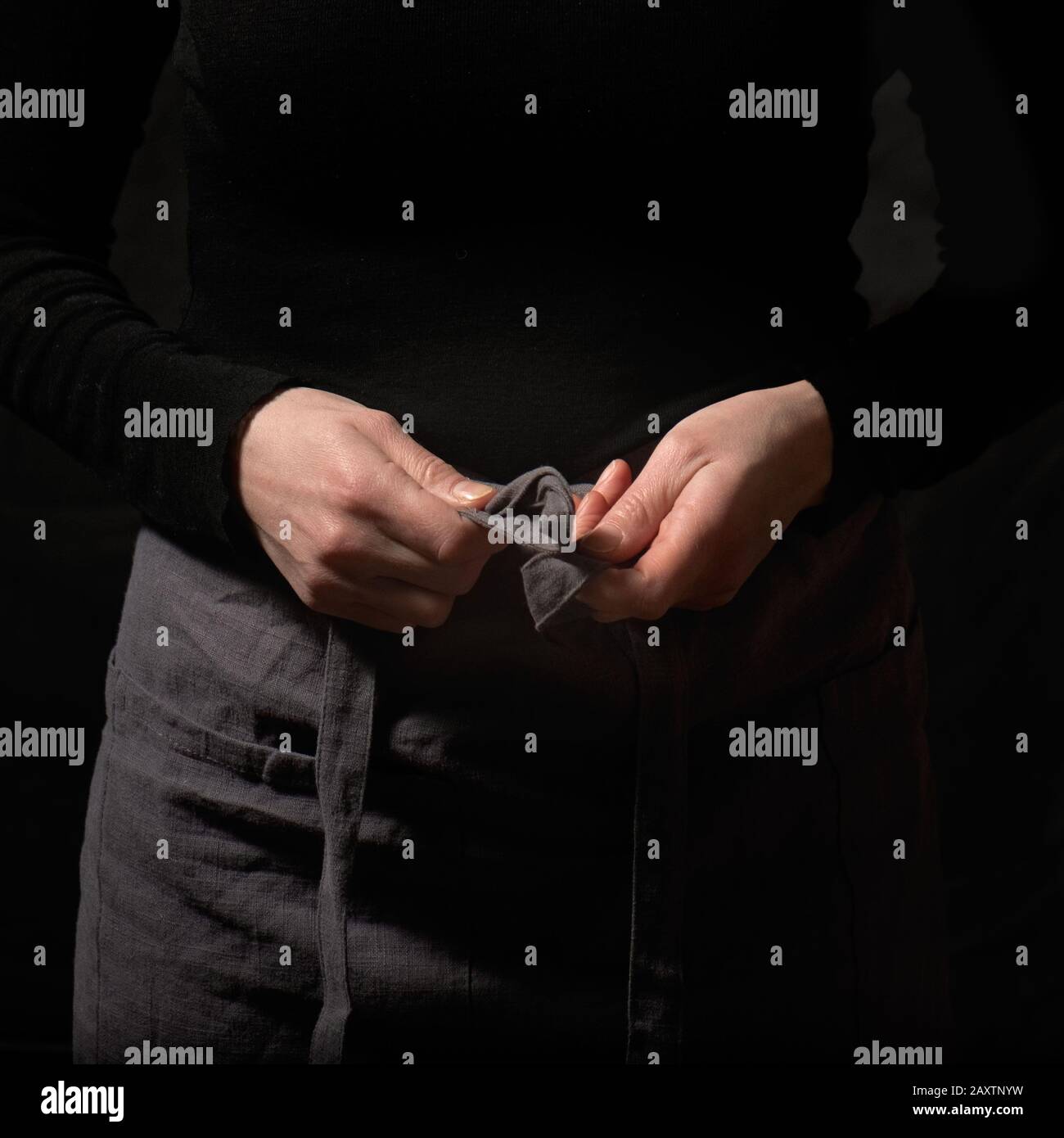 hands tying an apron Stock Photo - Alamy