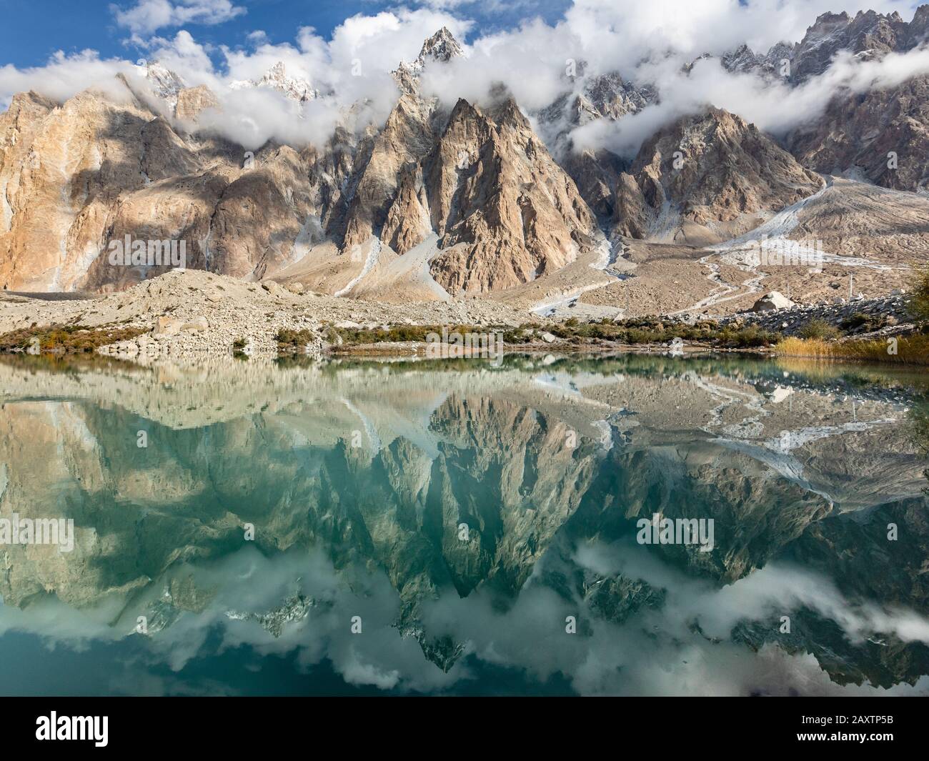 passu cones Karakorum mountain range reflection mirror lake cloudy ...