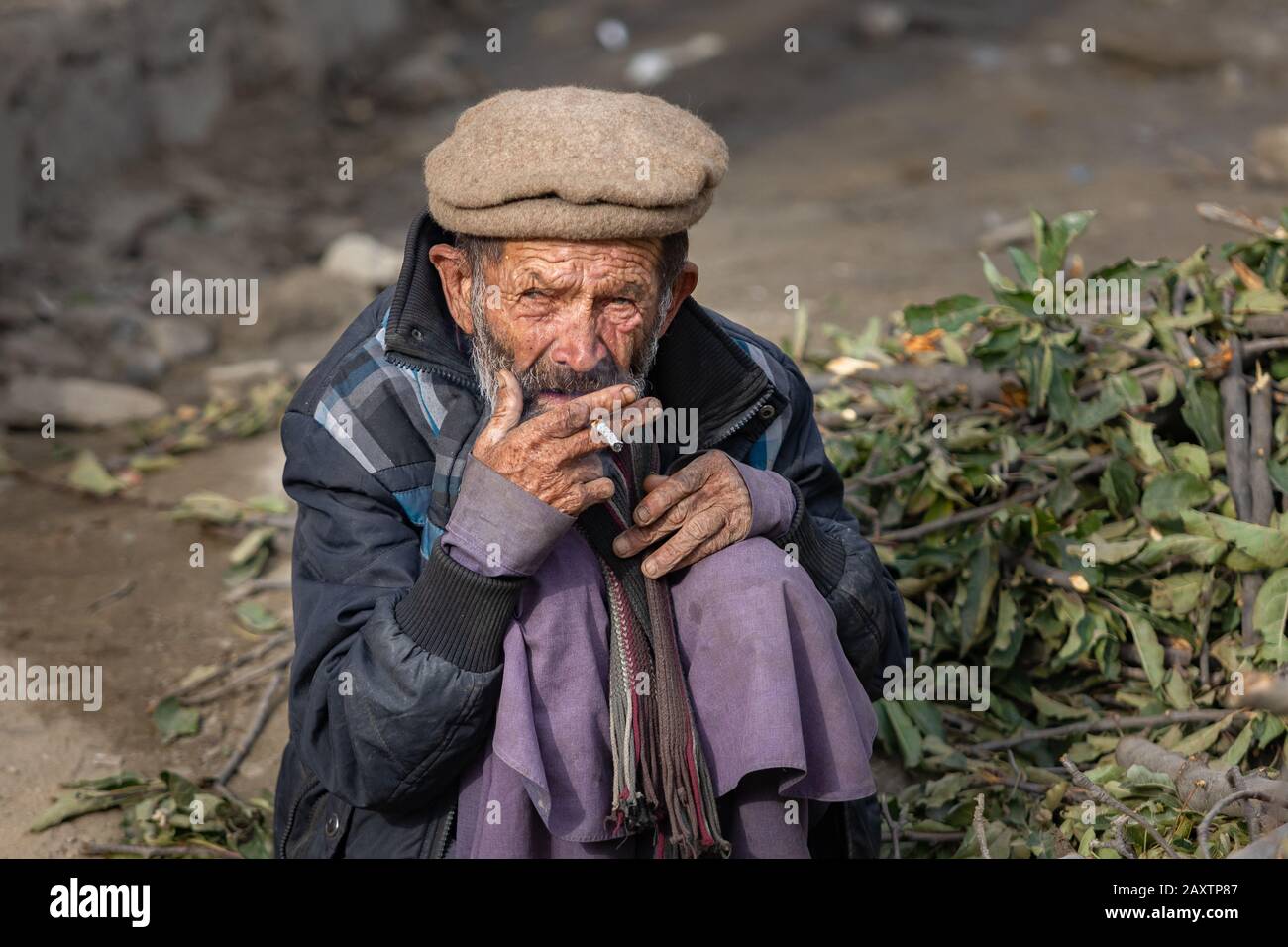 smoking old man in traditional clothes Stock Photo - Alamy