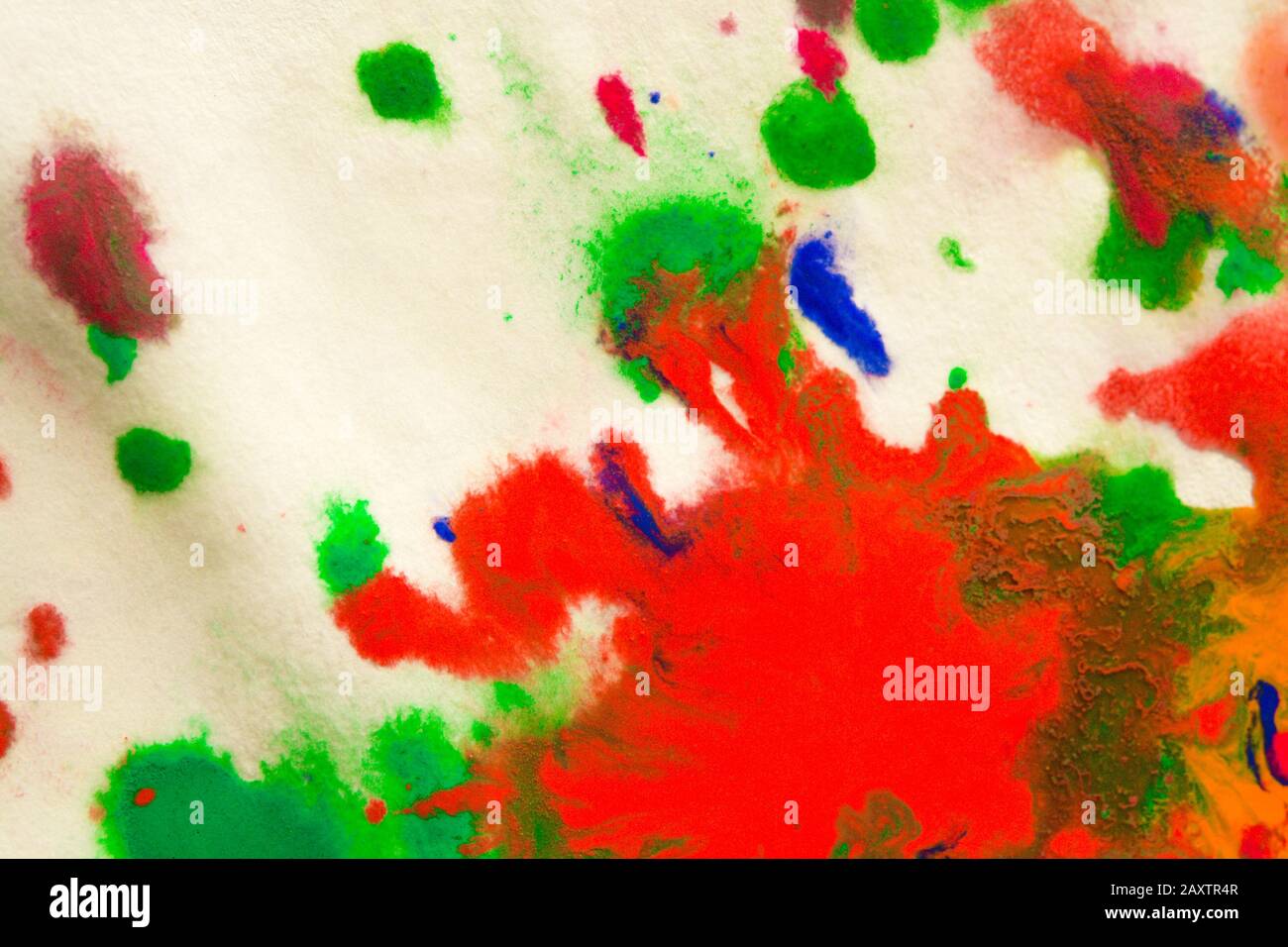 abstract spots splash of bright red, green, blue colors on white paper ...