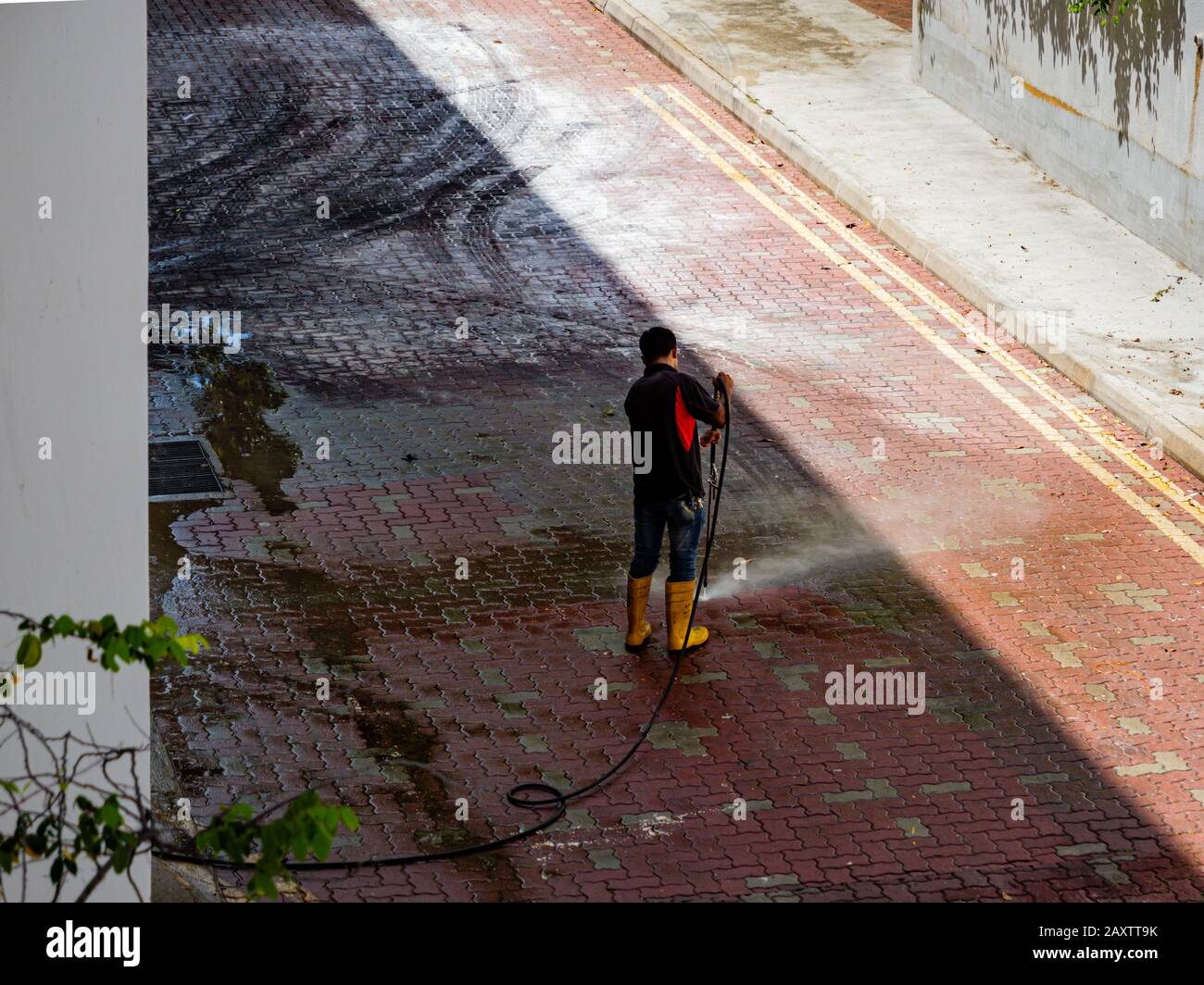 SINGAPORE – 5 JAN 2020 – A male cleaner cleaning the pavement in a ...